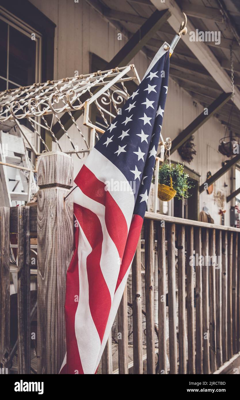 The Stars and Stripes of the American flag hanging from the veranda of ...