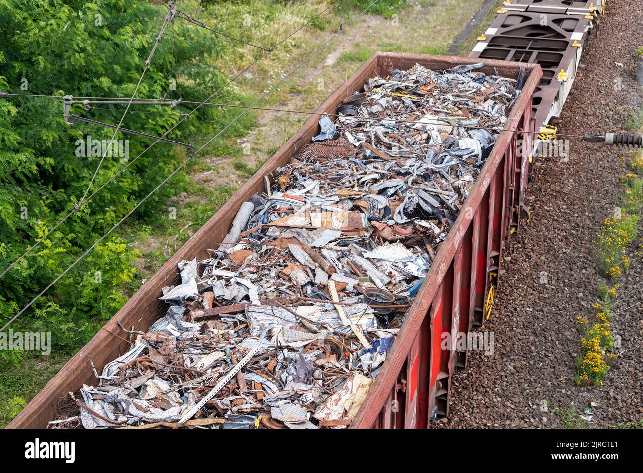 Above view of railway cargo train wagon filled by old rusty black metal ...