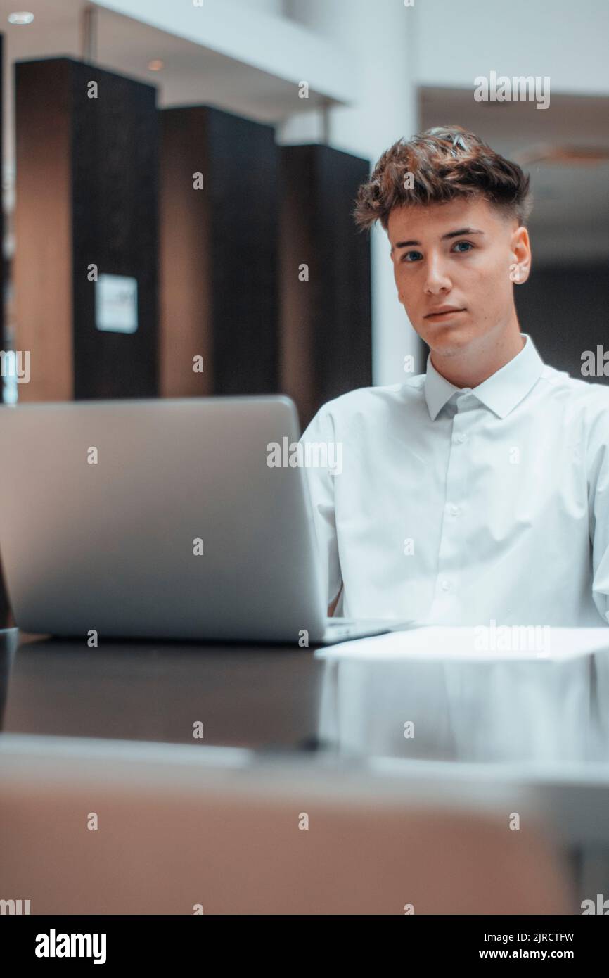 A handsome young business boy working on a laptop in the office Stock ...
