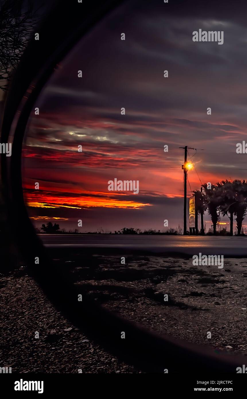 The sunset is reflected in a car mirror, January 7, 2016, at Cedar ...
