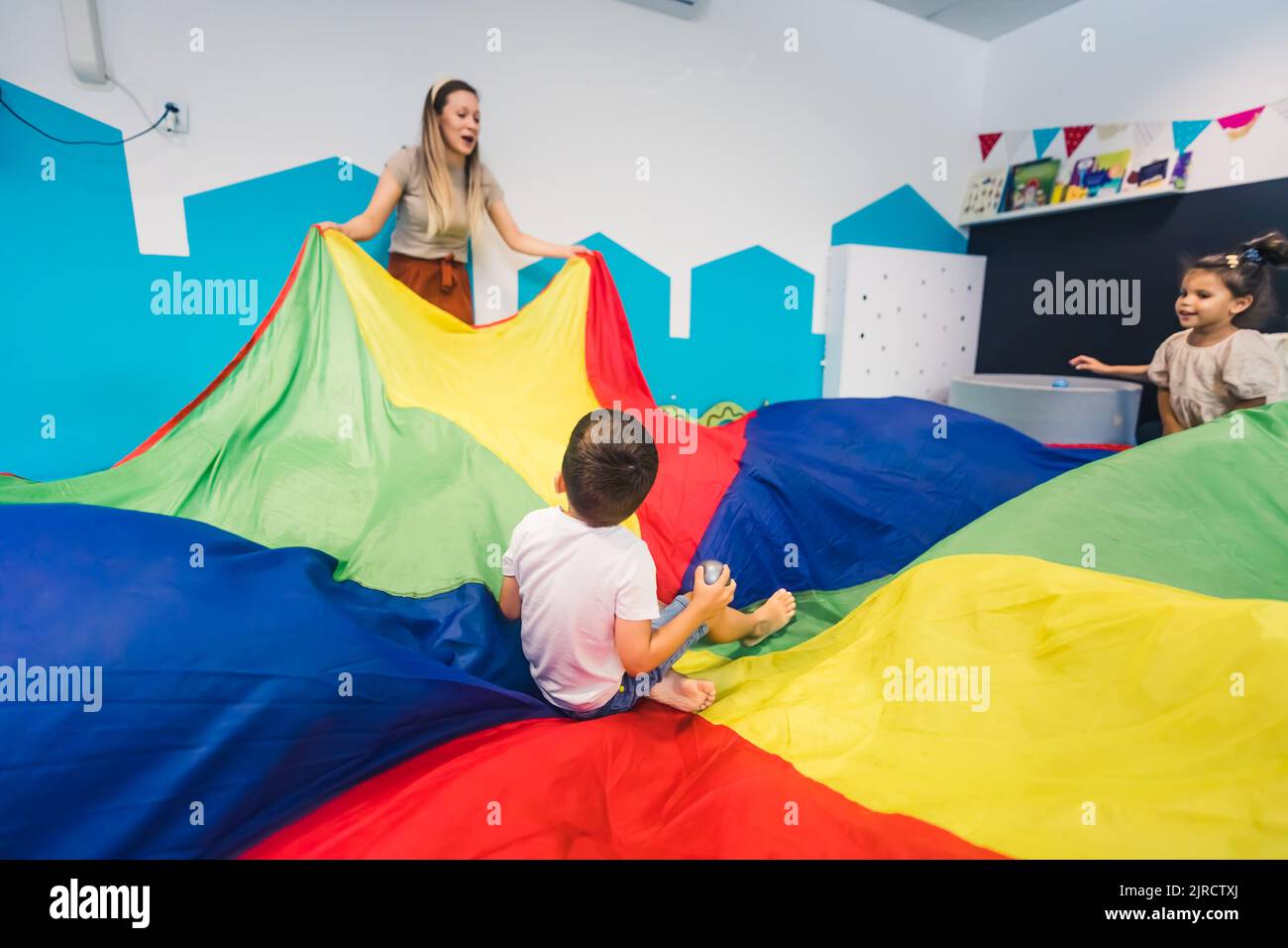 Happy toddlers having an active sensory play with texture and colors at ...