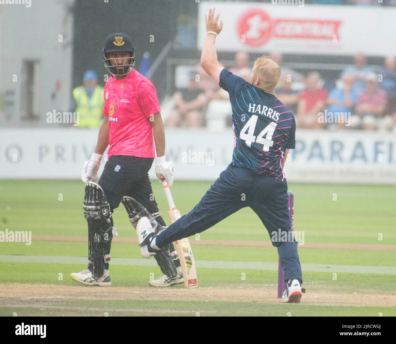 Max Harris bowls as the rain covers the Hove County Ground Stock Photo ...