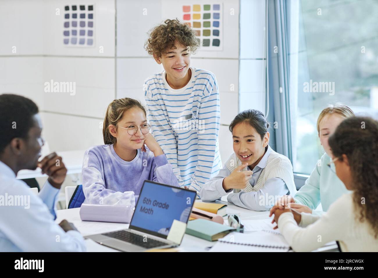 Diverse children smiling happily while enjoying group activity in math ...