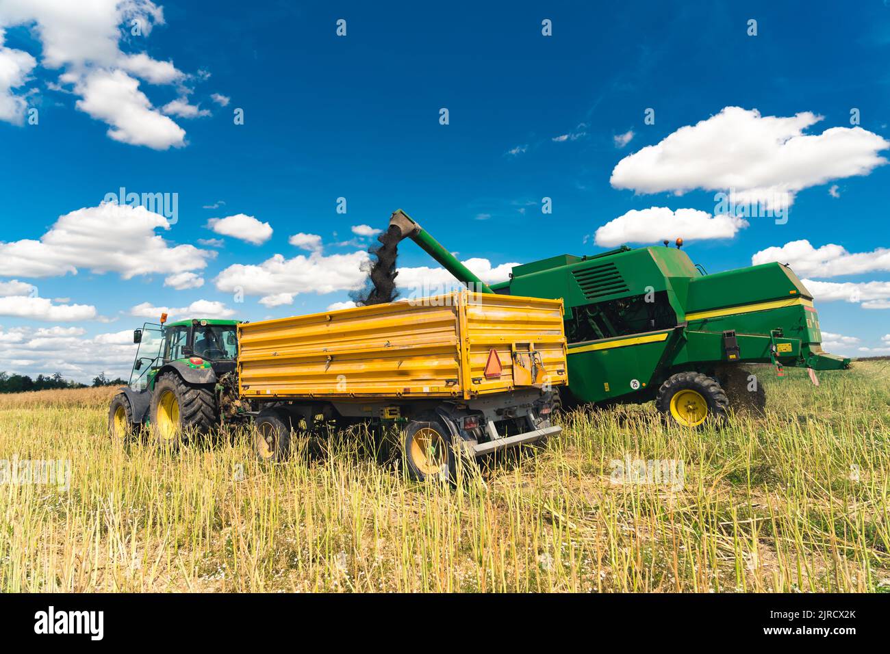 Two agricultural machines - combine harvester and tractor with a ...