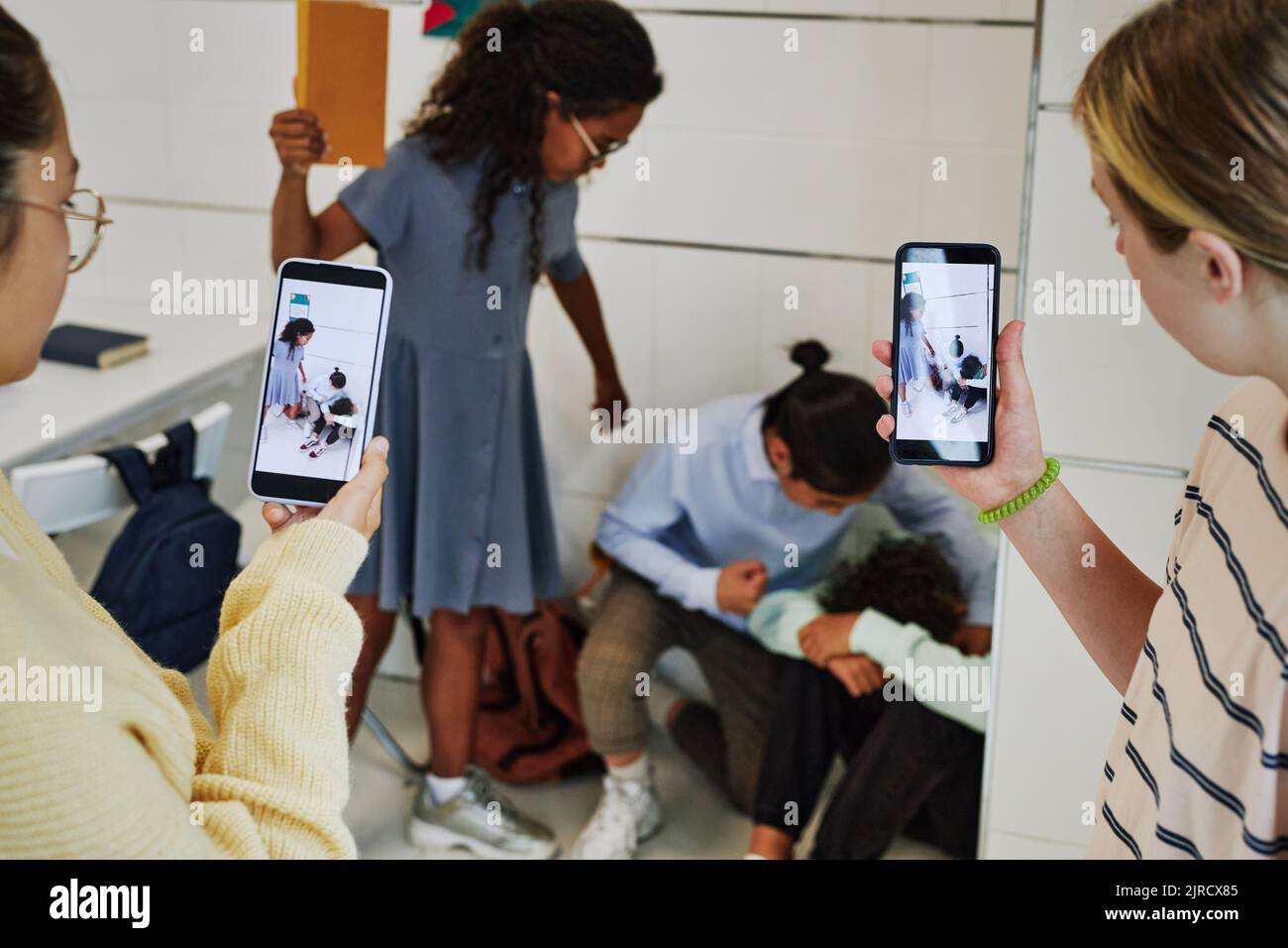 School bullying scene with children recording fight on smartphone ...