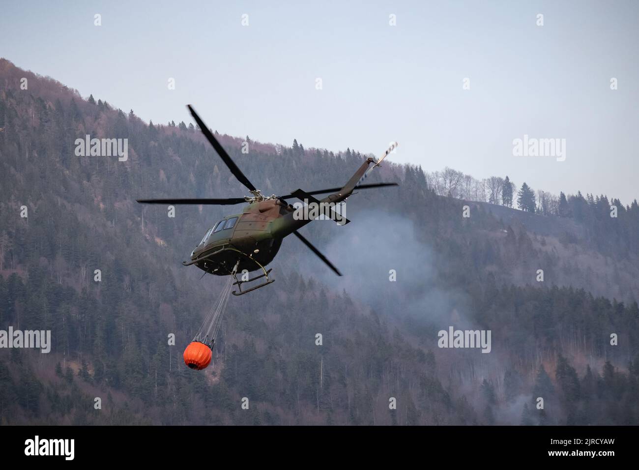 The helicopter carrying a bucket to deliver water for aerial ...