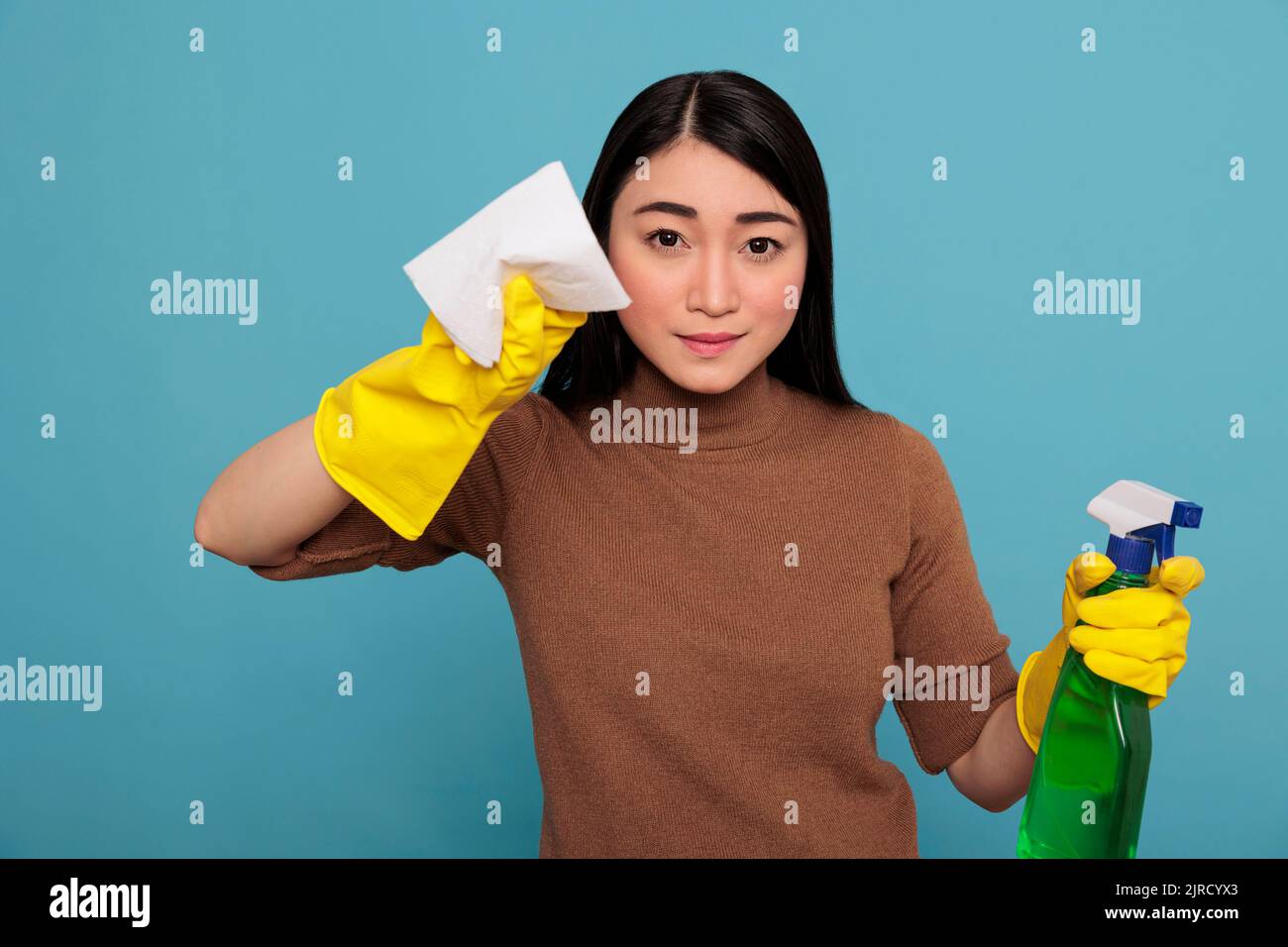 Smiling happy asian maid from daily cleaning work with tissue paper ...