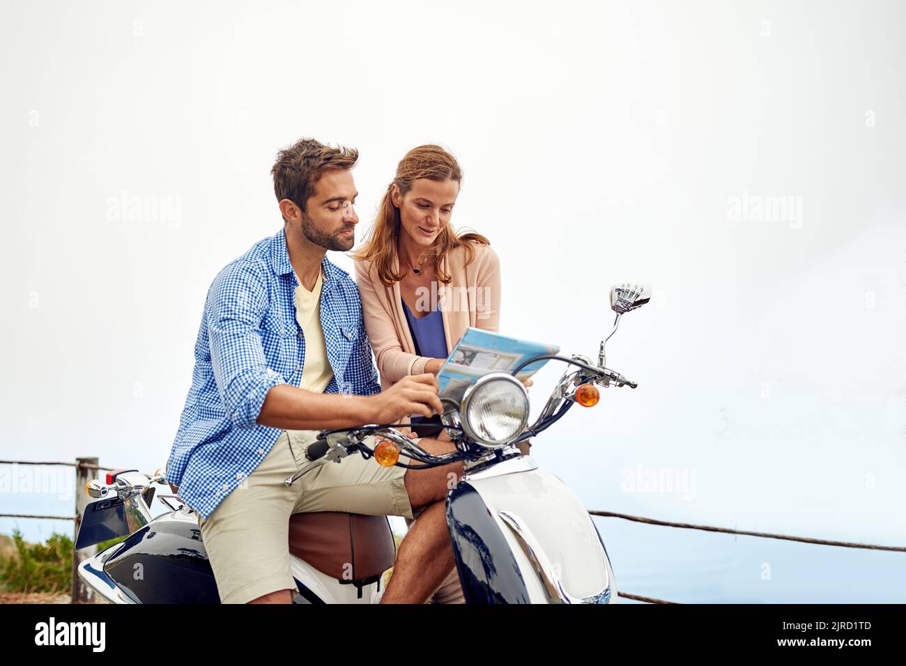 Taking a trip on two wheels. an affectionate couple looking at a map ...