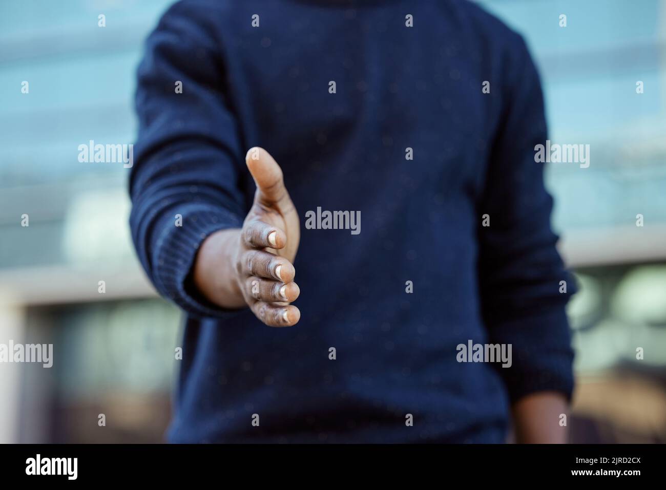 Welcome, trust and support, a man with his hand out for a handshake. A ...
