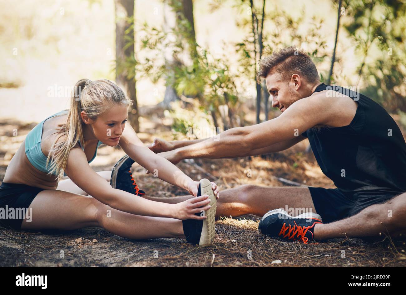 Couples that train together remain together. a young couple stretching together outdoors Stock ...