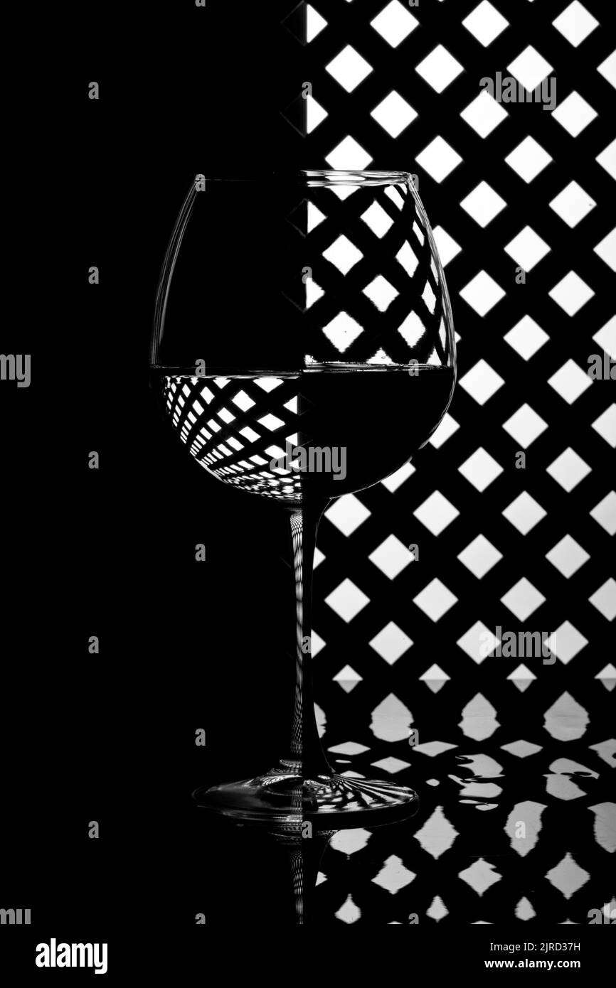 Still life with a glass with liquid on a grid background Stock Photo ...