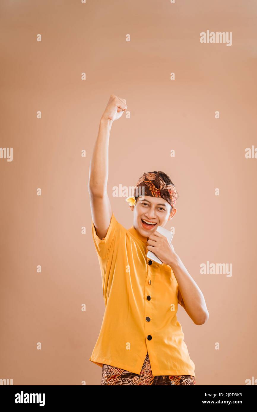 excited young balinese male put his hand up Stock Photo - Alamy