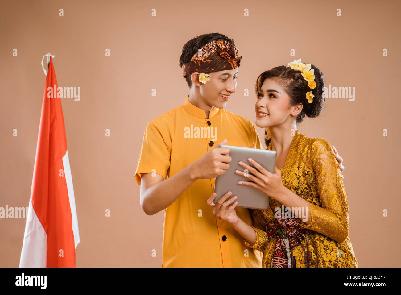 man and woman wearing balinese traditional clothing using tablet Stock ...
