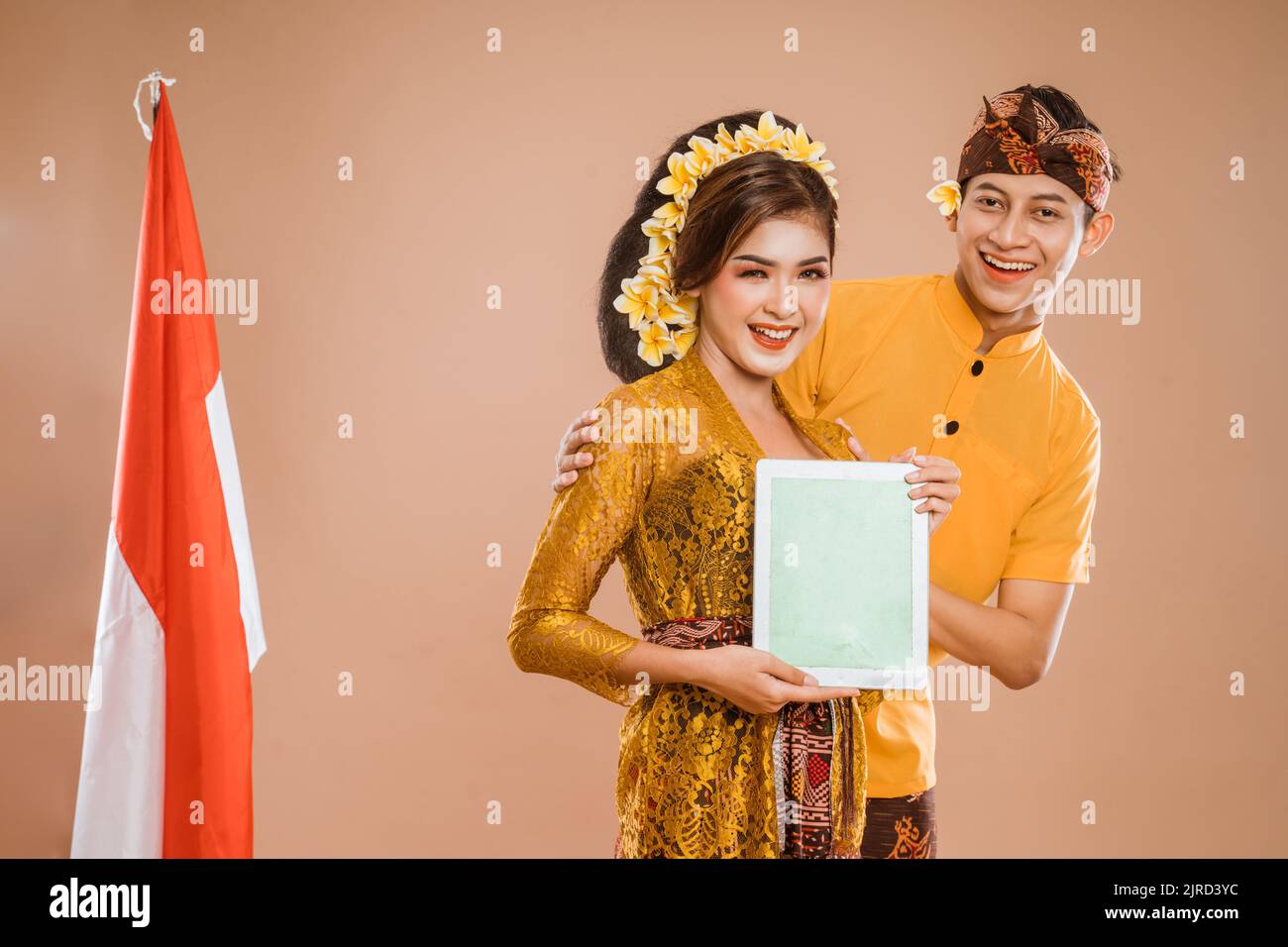 balinese young couple showing tablet screen to camera Stock Photo - Alamy