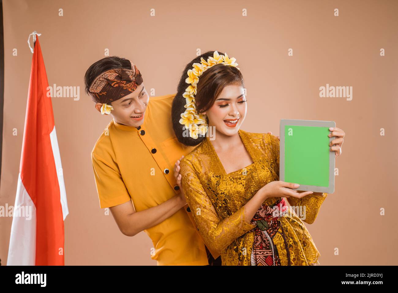 balinese young couple showing tablet screen to camera Stock Photo - Alamy