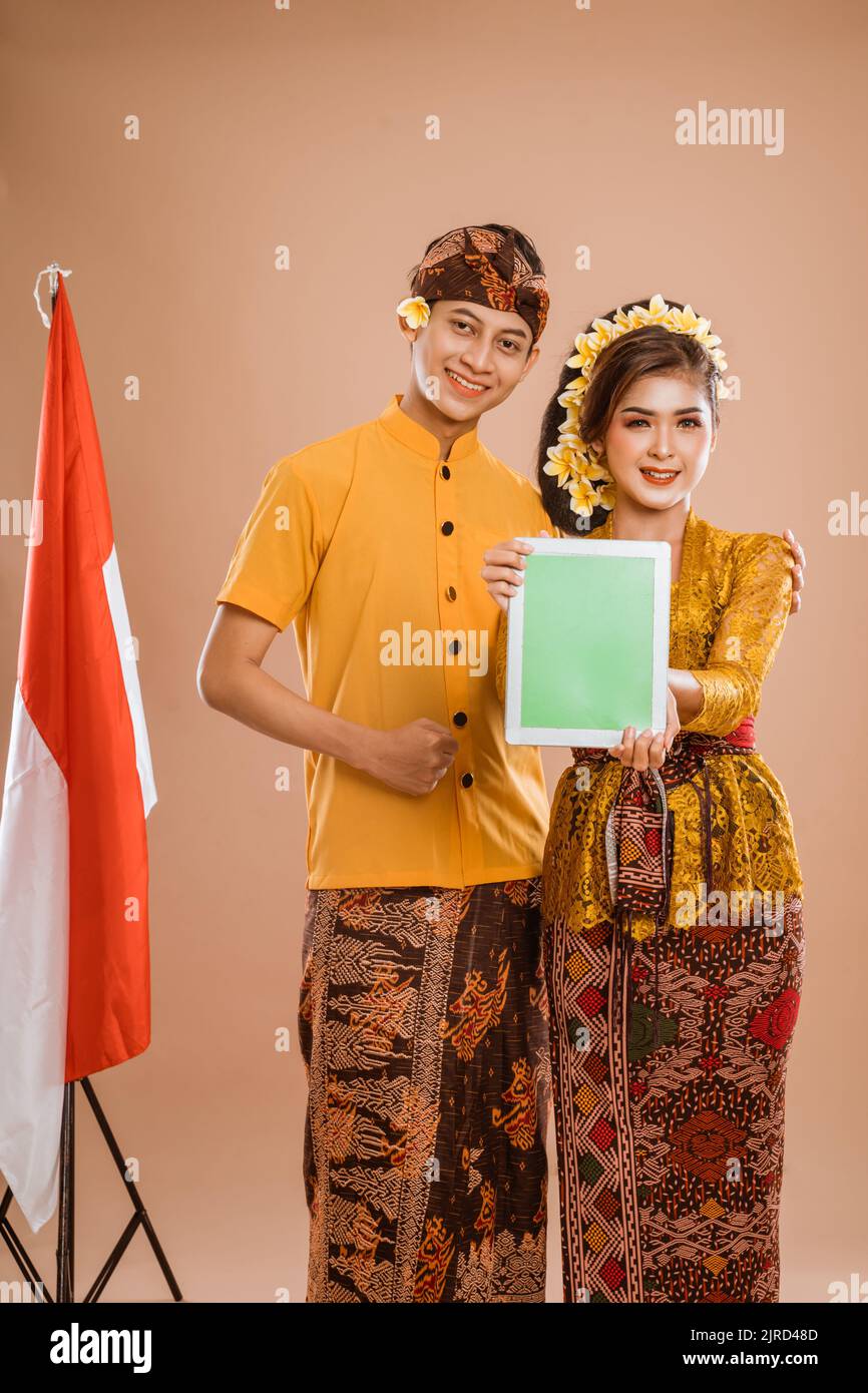 balinese young couple showing tablet screen to camera Stock Photo - Alamy