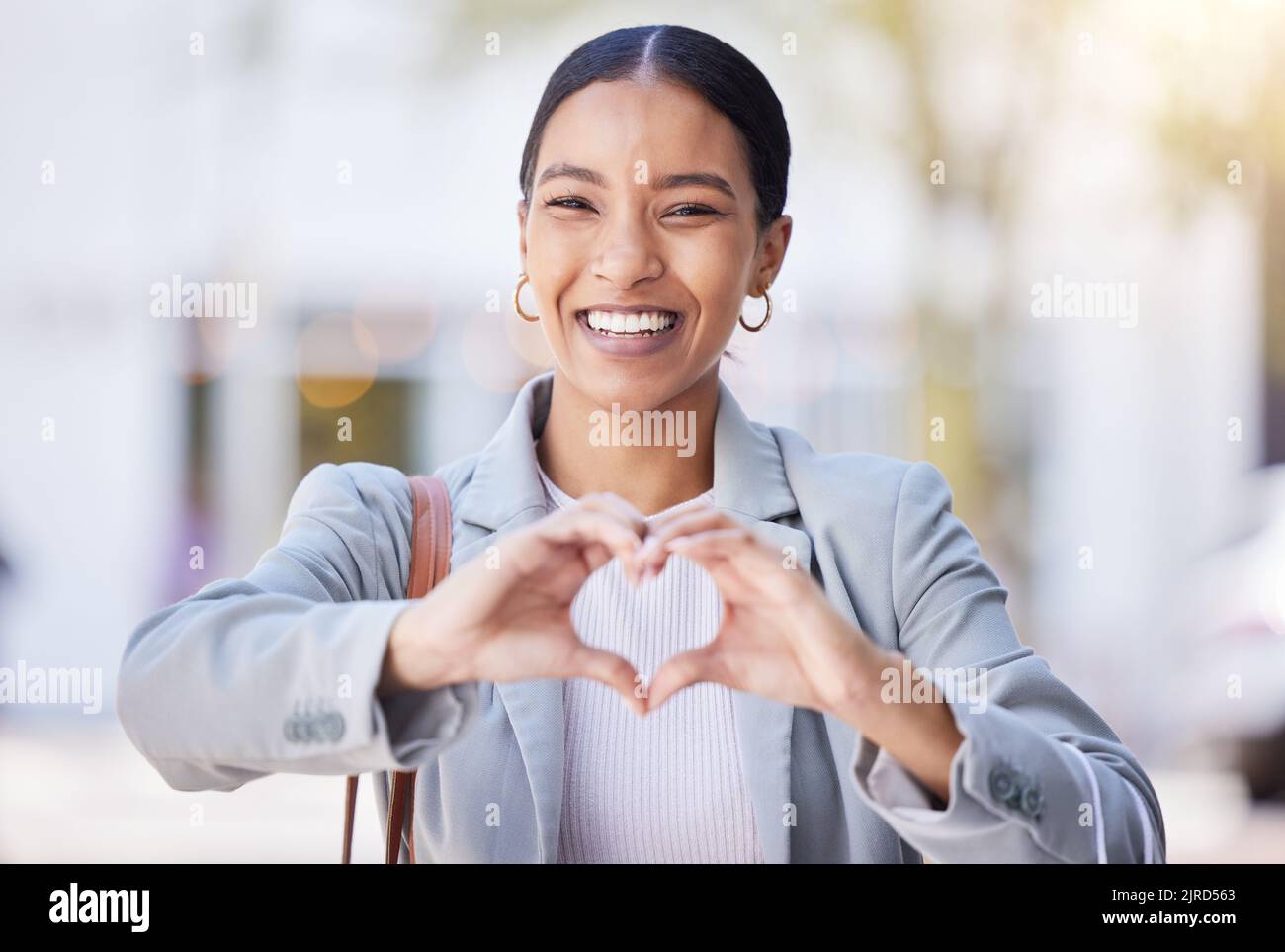 Love, heart and happy hand sign of a young female with a smile with a ...