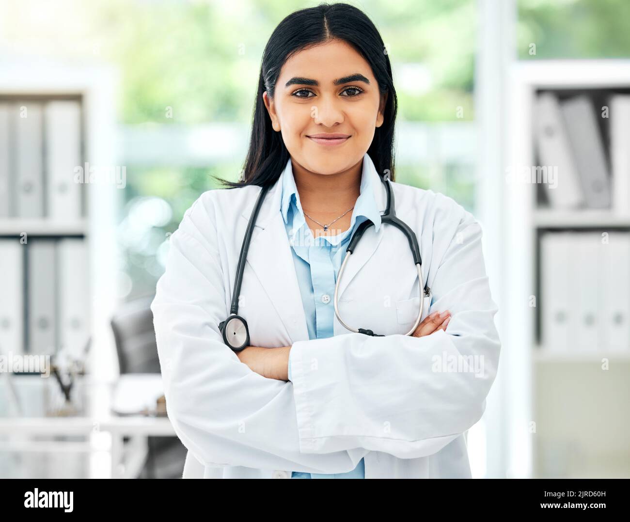 Portrait of a doctor working in her office with medical equipment at a ...
