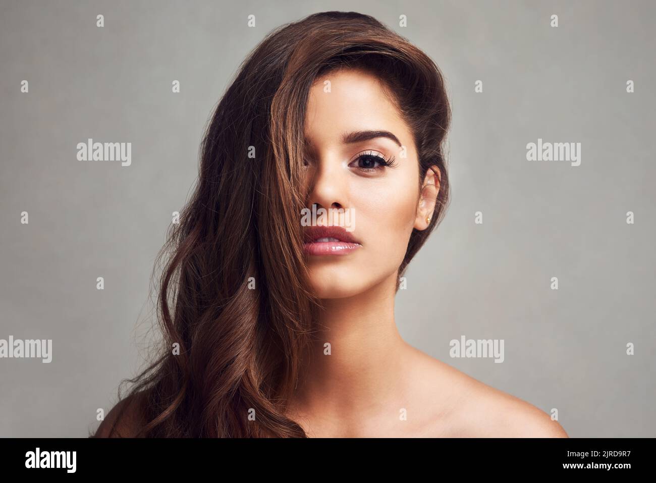Beauty is flowing hair and glowing skin. Studio shot of a young beautiful woman with long ...