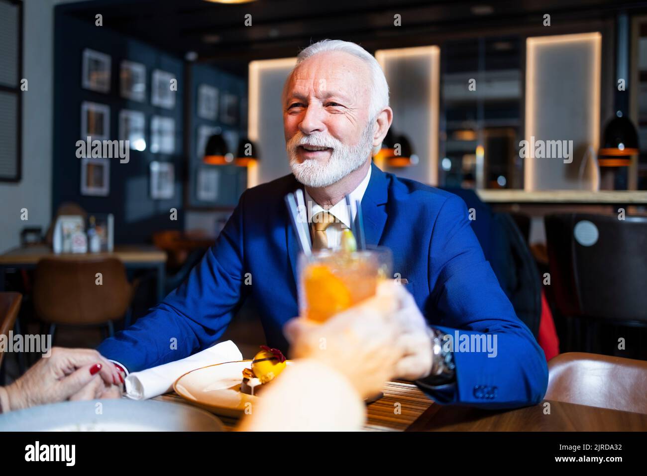 Happy senior man smiling and toasting in a restaurant Stock Photo - Alamy