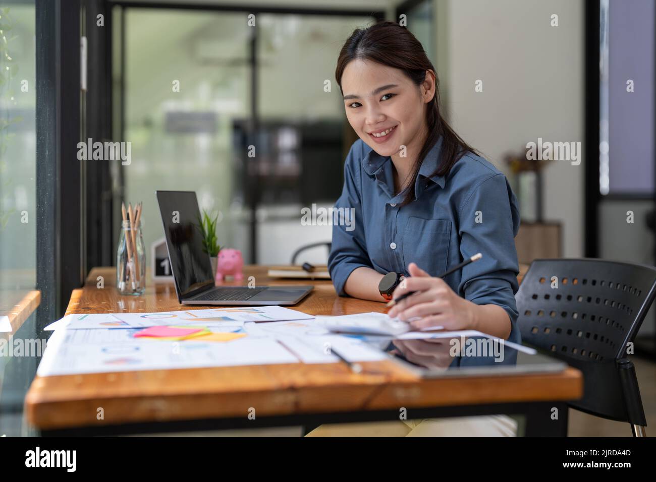 Portrait asian accountant or auditor working with calculator and laptop ...