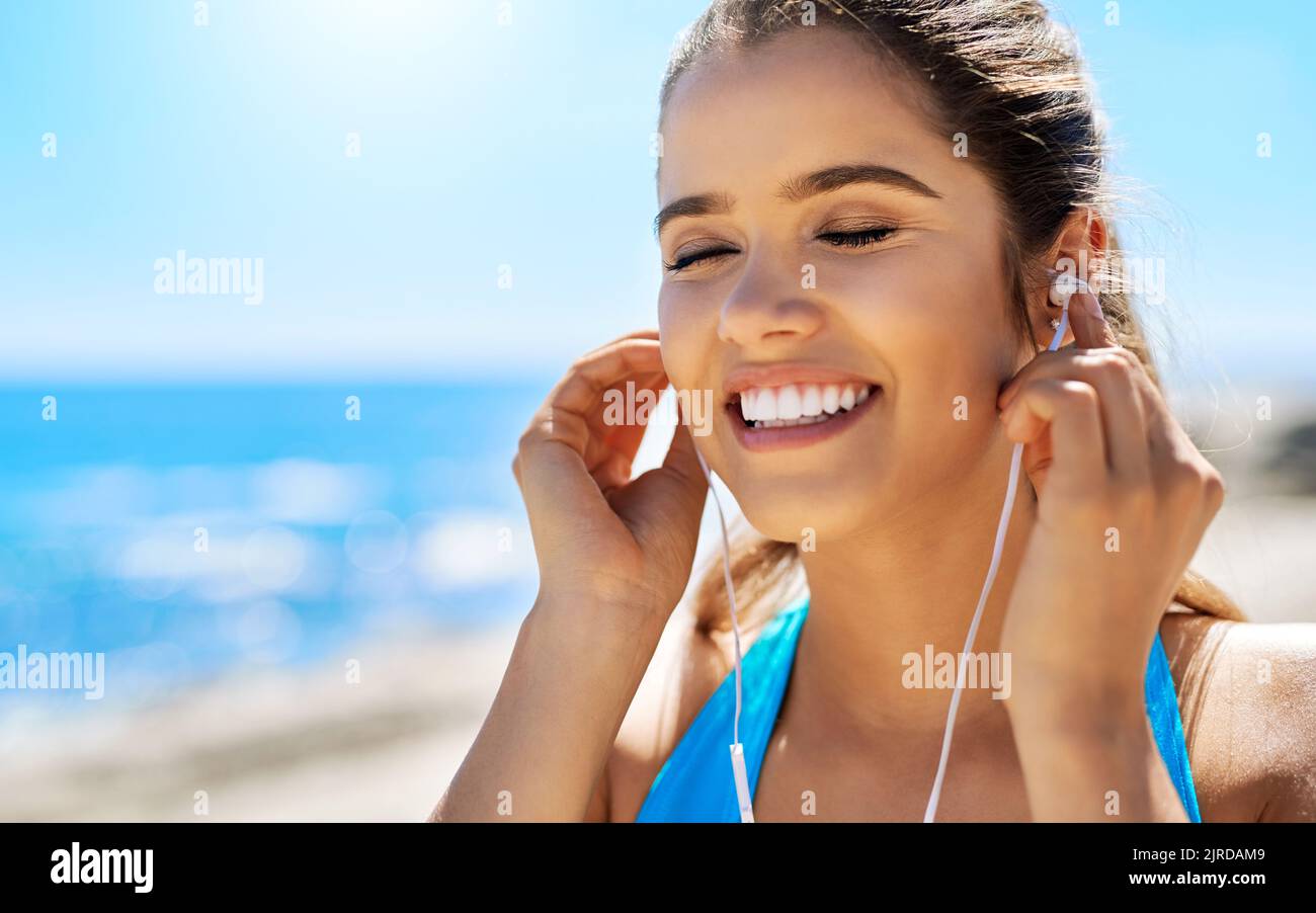 Music makes you want to move. a young woman listening to music while ...