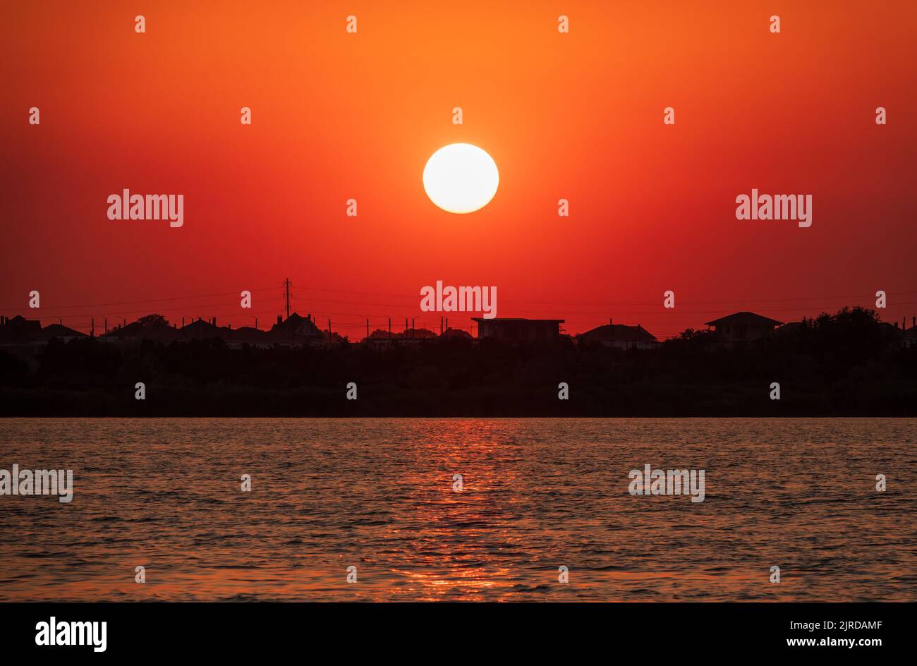 The sun goes down over a lake. Dramatic Sunset Sky Stock Photo - Alamy