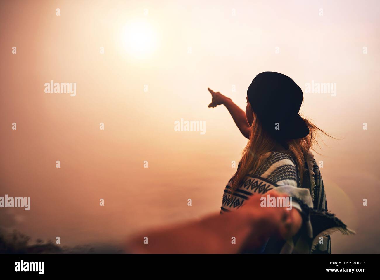 Chasing the horizon together. an unidentifiable young hiker pointing ...