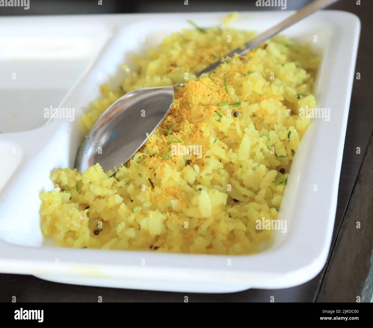 A close-up shot of a poha dish with flattened rice used as breakfast by ...