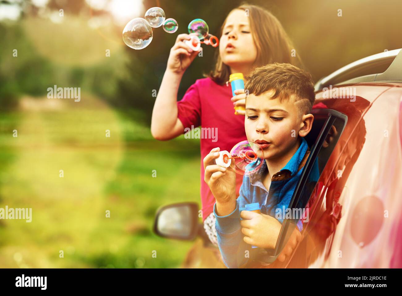 The more bubbles, the better. two happy children blowing bubbles while ...