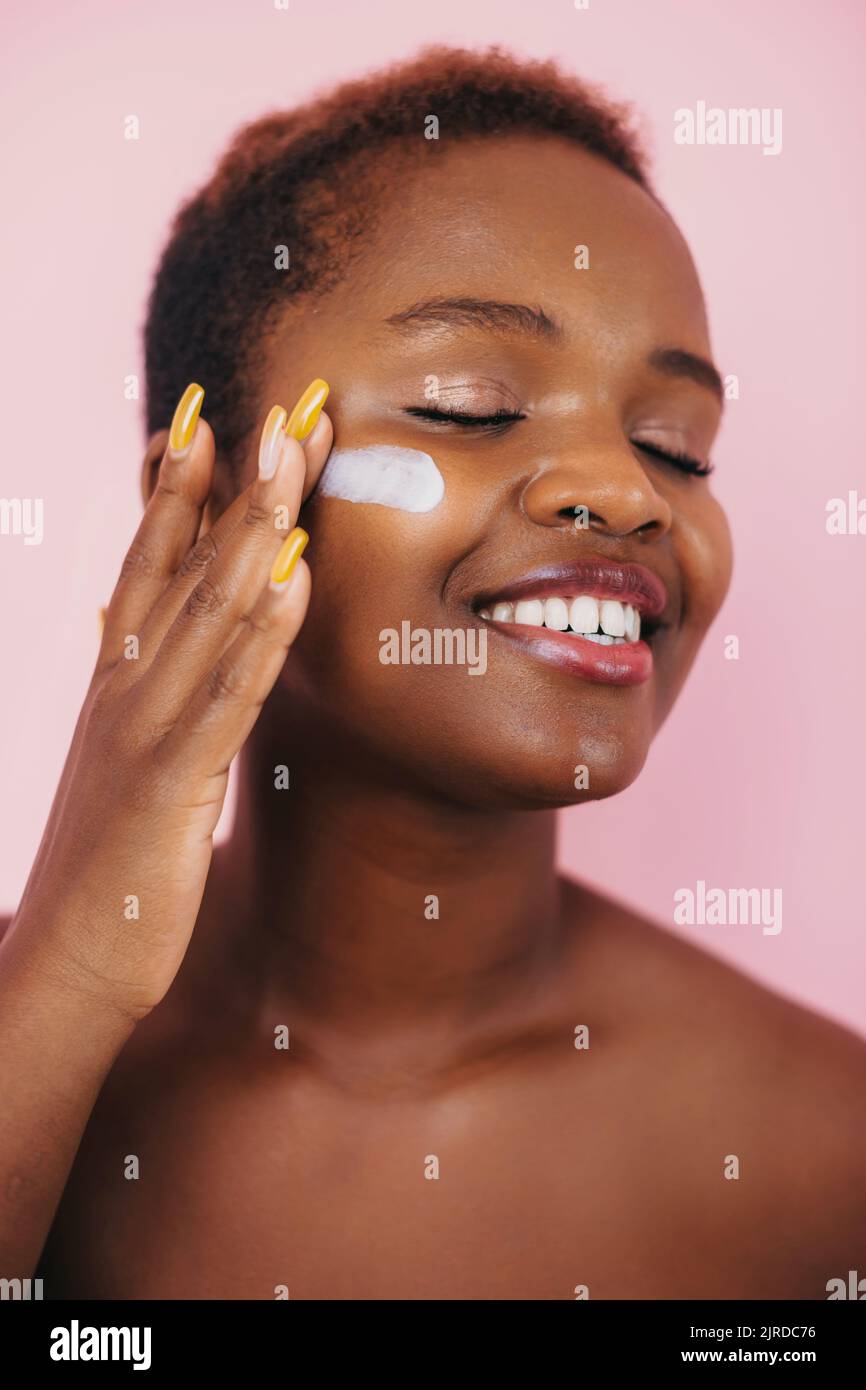 Beautiful African American Woman Applying Moisturizing Cream On Her