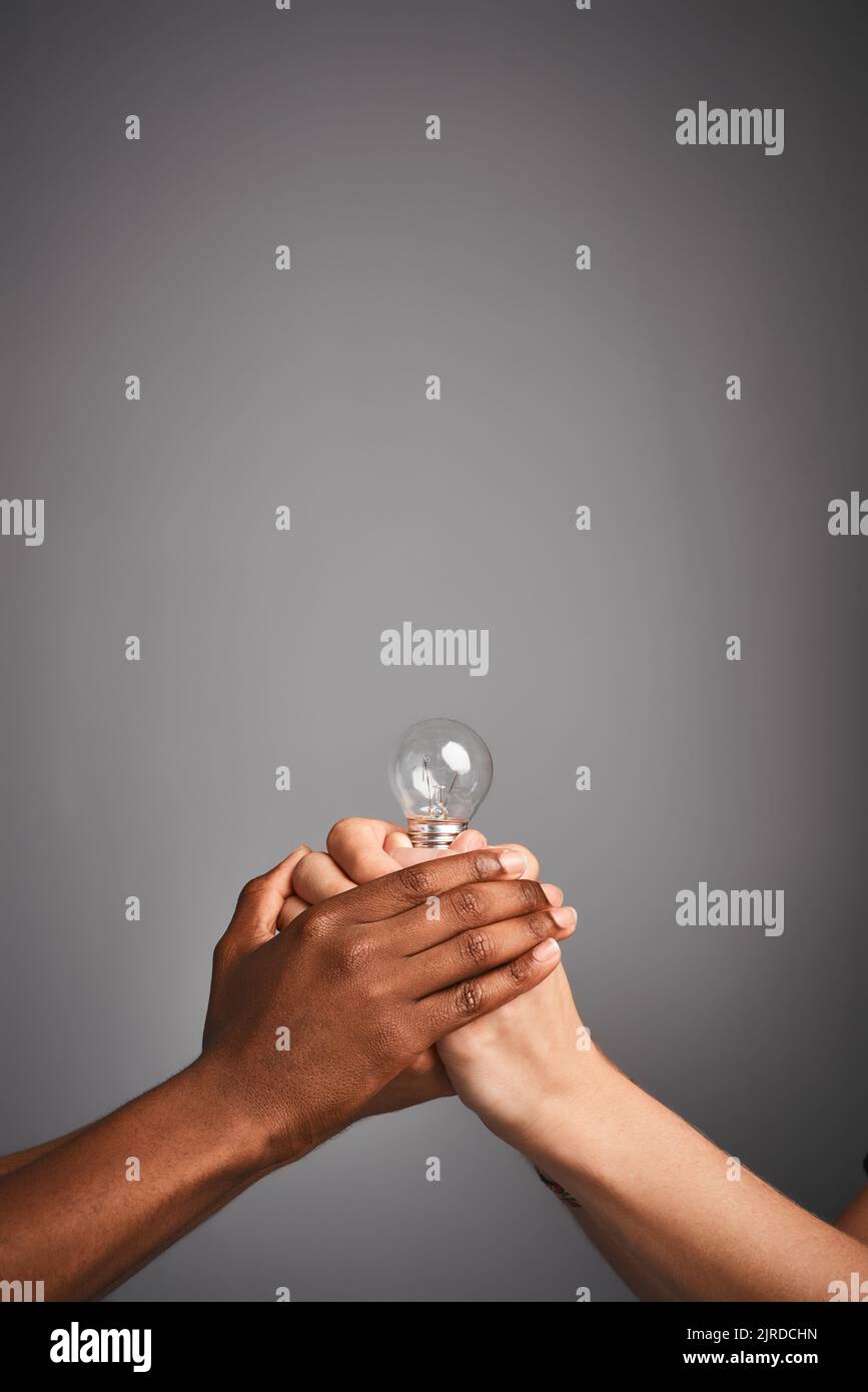 Light up someone elses day. Studio shot of unidentifiable hands holding ...
