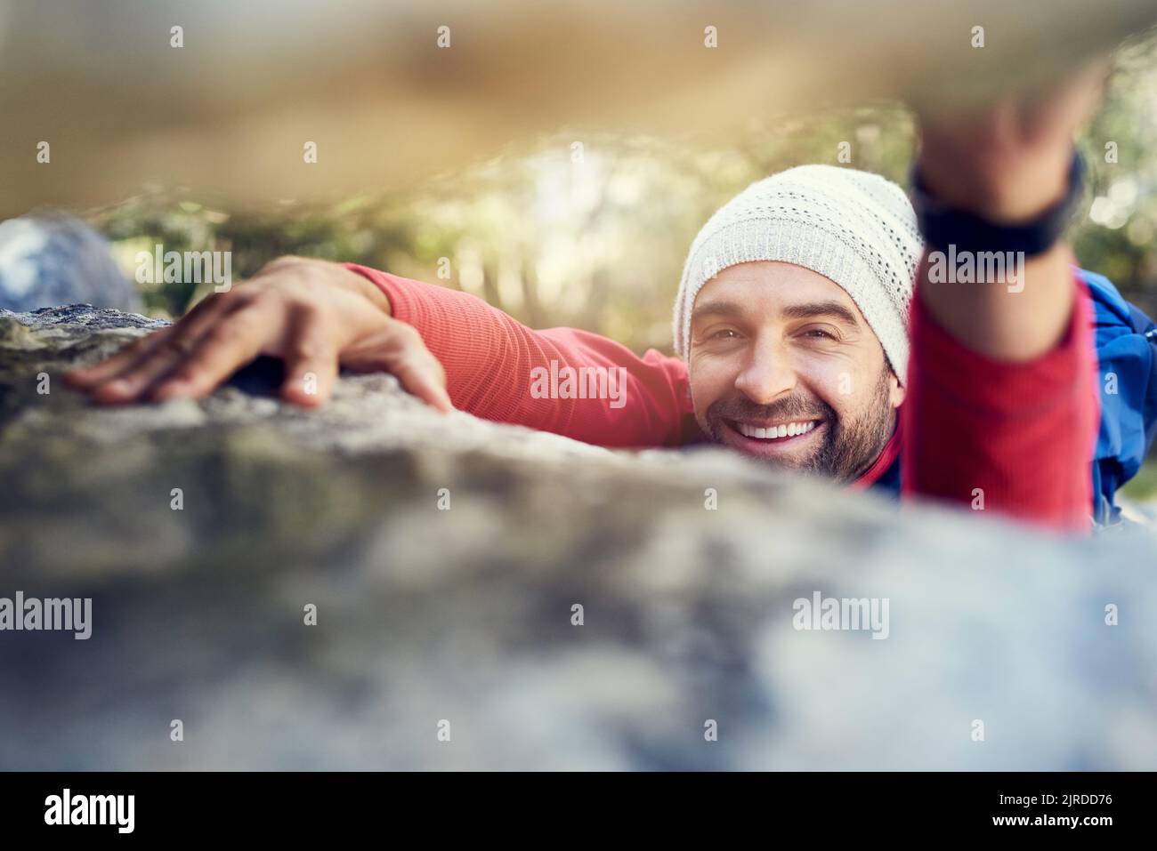 Im on my way to the top. Portrait of a happy hiker climbing over rocks ...