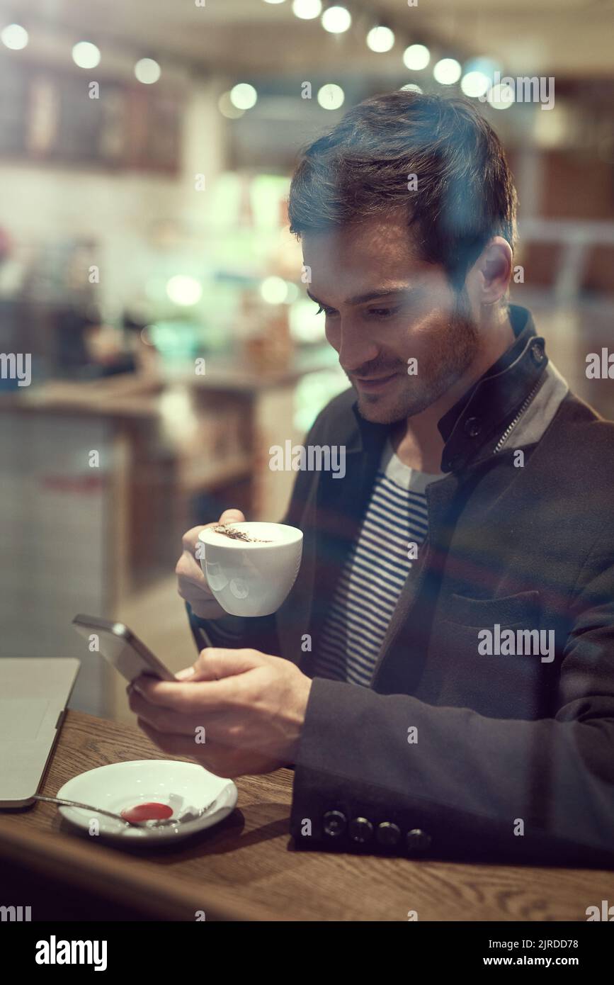 Im grabbing a coffee quick. a handsome young man using his cellphone ...