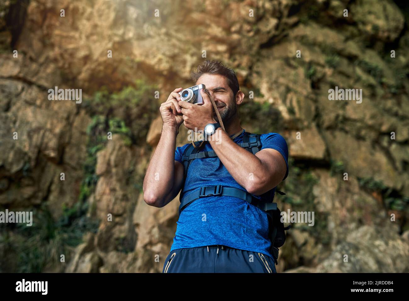 Snapping memories along his hike. a young man taking photos while out ...