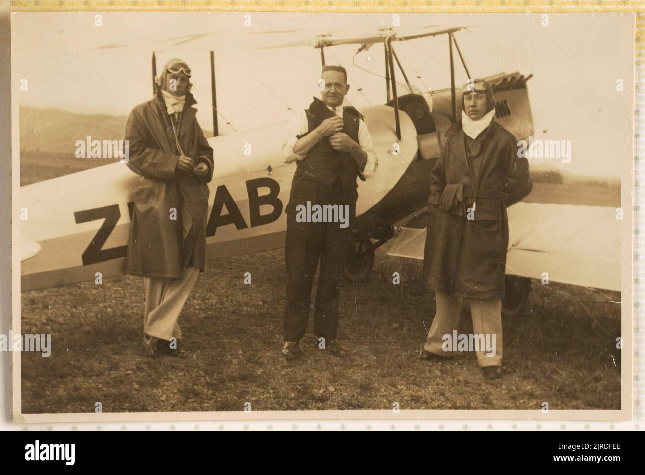 Three men and a biplane. From the album: James Cane photograph album ...