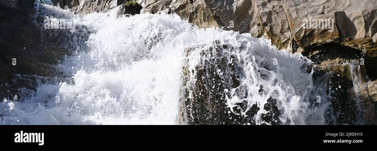 Rapid waterfall with foaming water in rocks background Stock Photo - Alamy