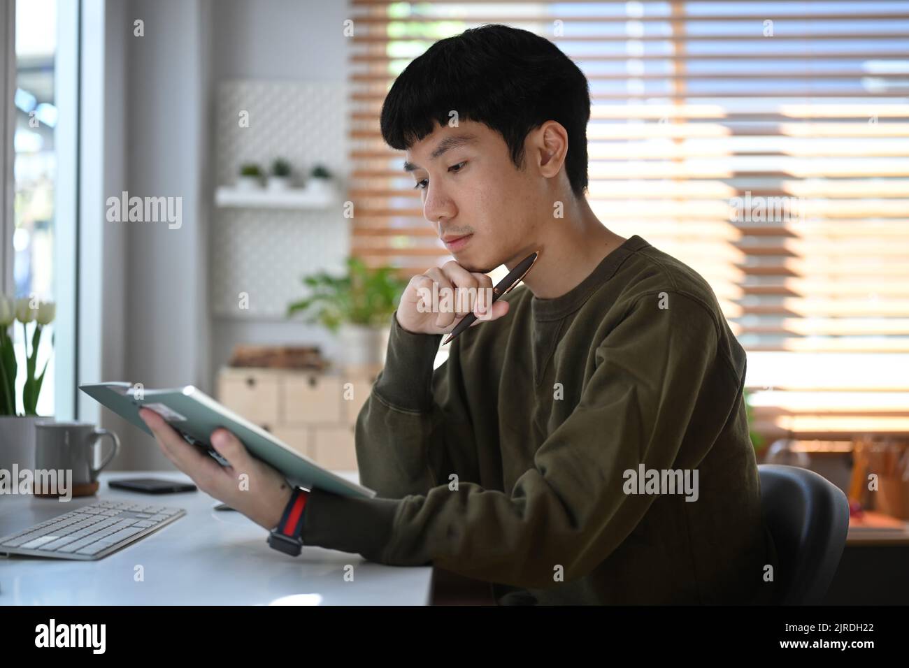Thoughtful asian man making important notes, agenda plan planning daily ...