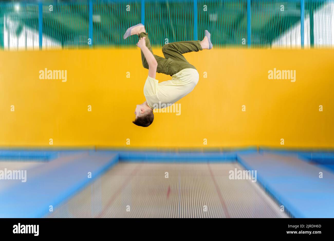 Teenage boy jumping on trampoline park in sport center Stock Photo - Alamy