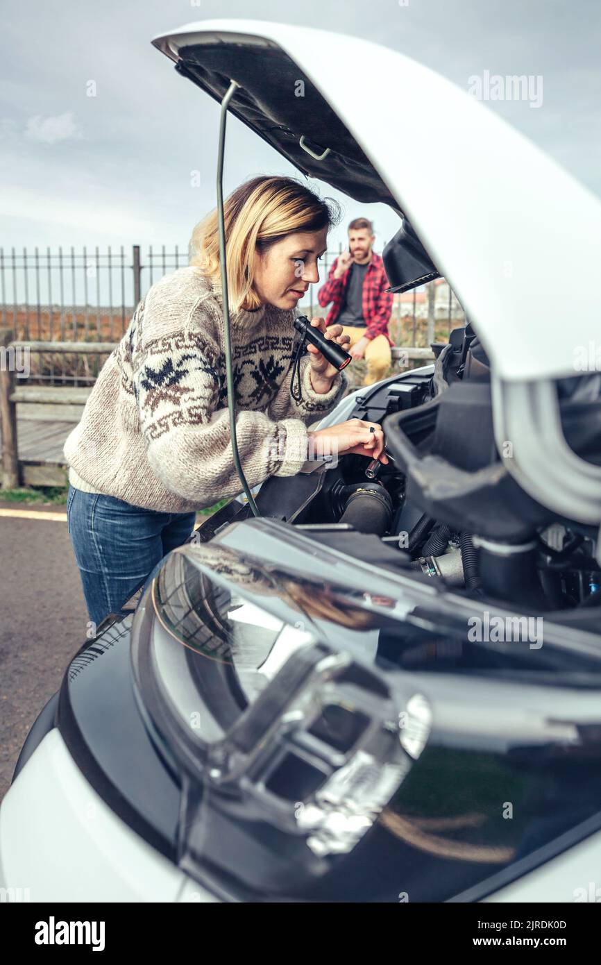 Woman repairing broken down campervan Stock Photo - Alamy
