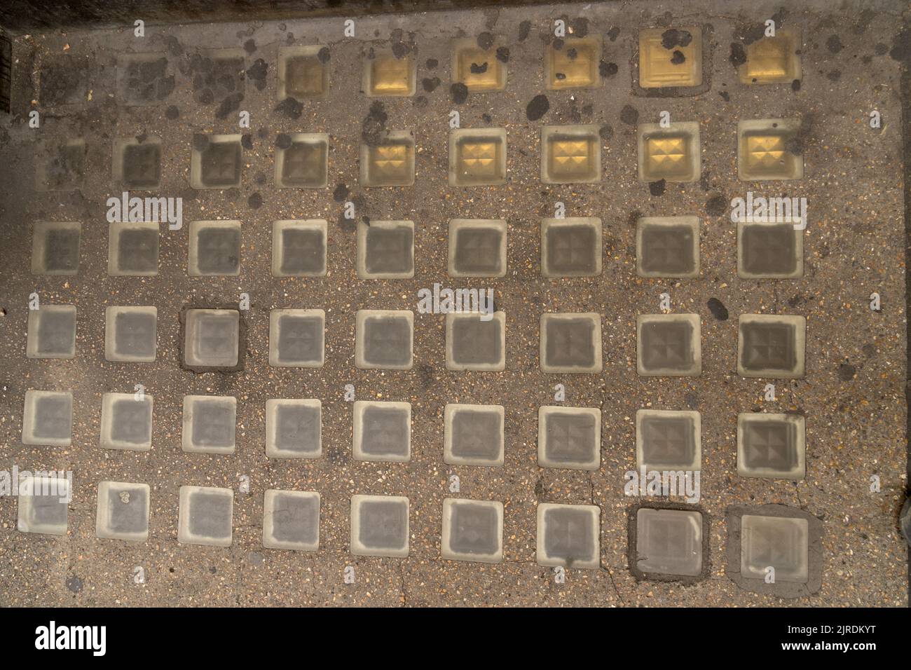Close up of glass blocks geometrically embedded in partially dirty ...