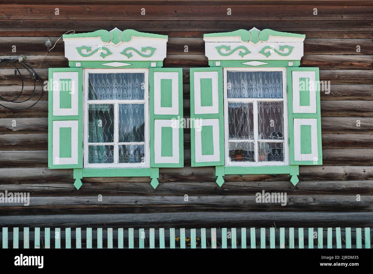 Old wooden windows with carved architraves. Log facade of typical rural ...