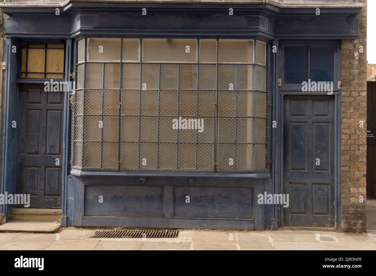 Close up of old uninhabited weathered blue house with barred store ...