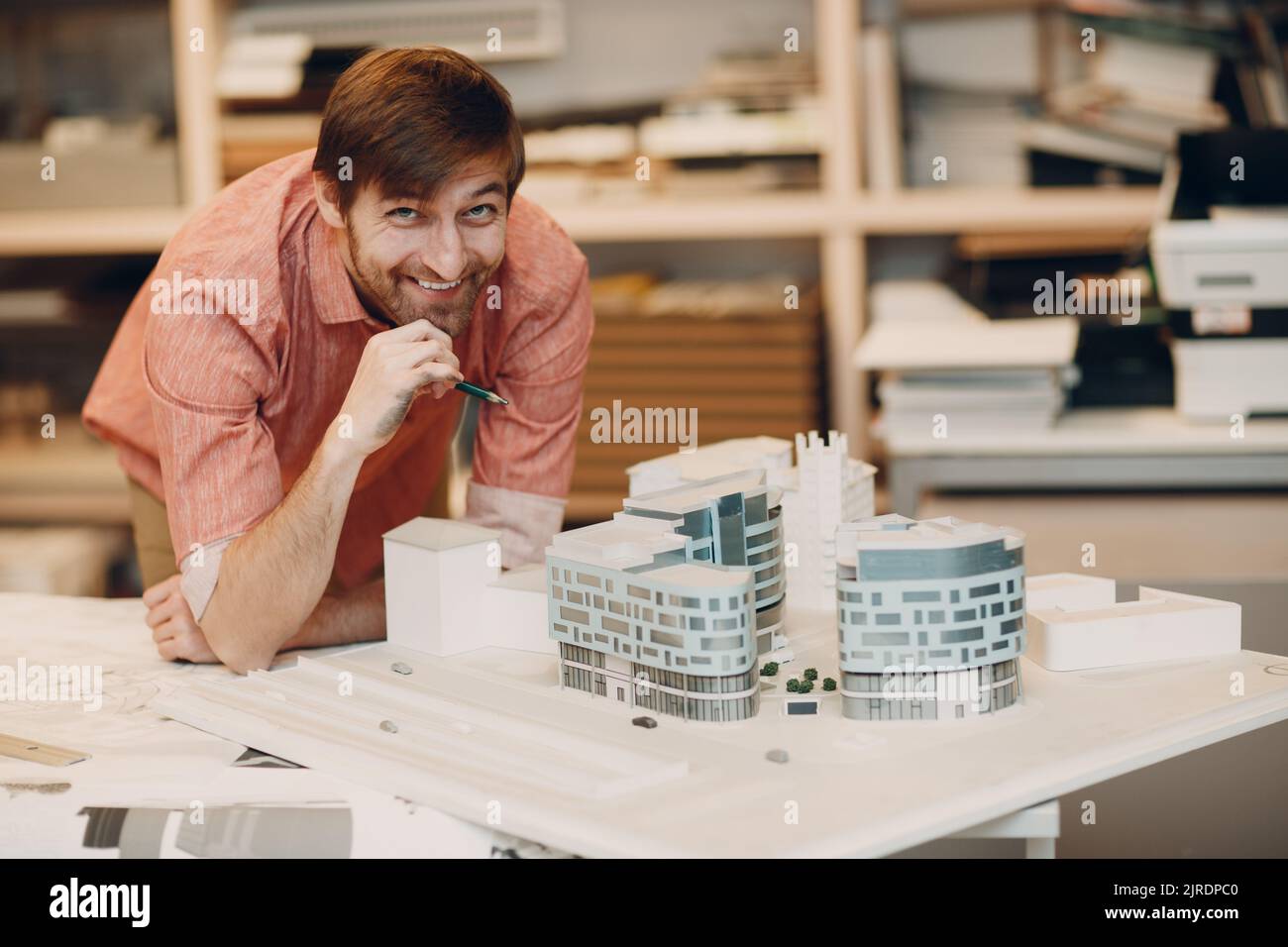 Young adult caucasian architect working at the table with project ...