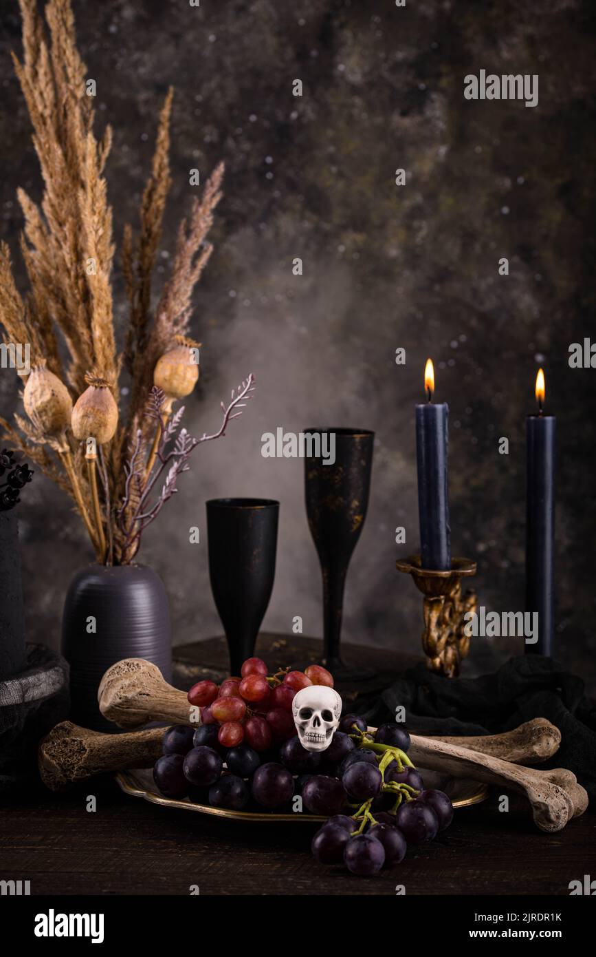 Halloween still life with skull, bones and cake Stock Photo - Alamy