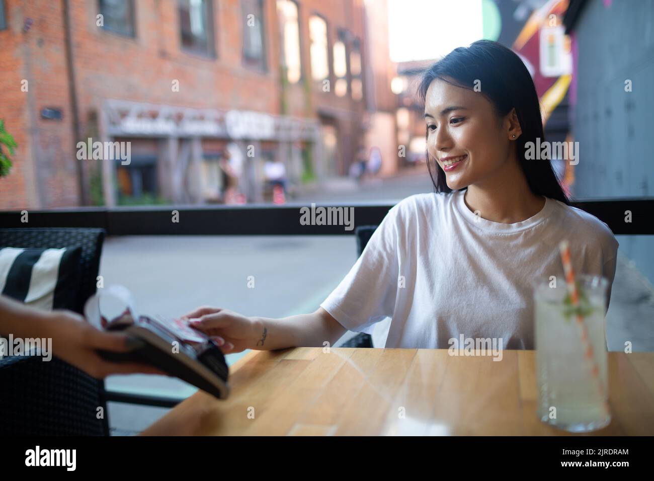 Asian Woman pay with credit card contactless payment terminal cashier ...