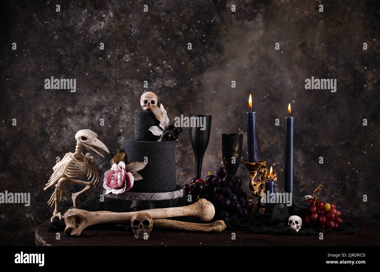 Halloween still life with skull, bones and cake Stock Photo - Alamy