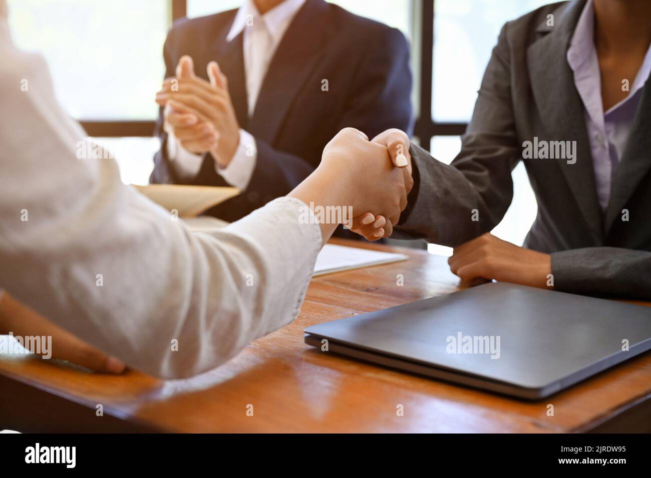 A businesswoman shakes hands with her business partner after the ...