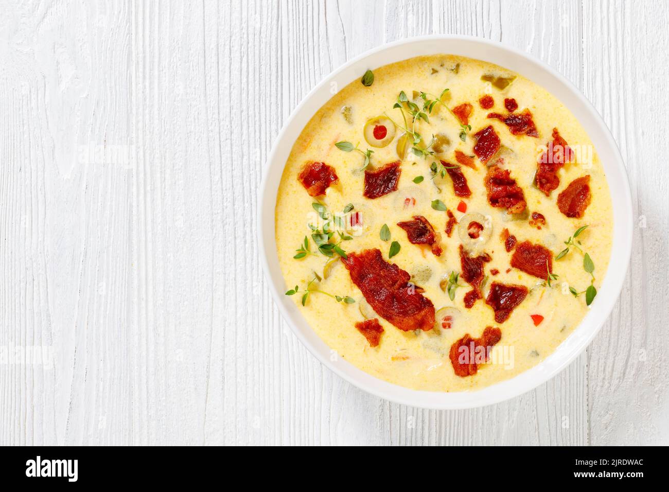 Beer cheese soup with red pepper stuffed green olives, vegetables and ...