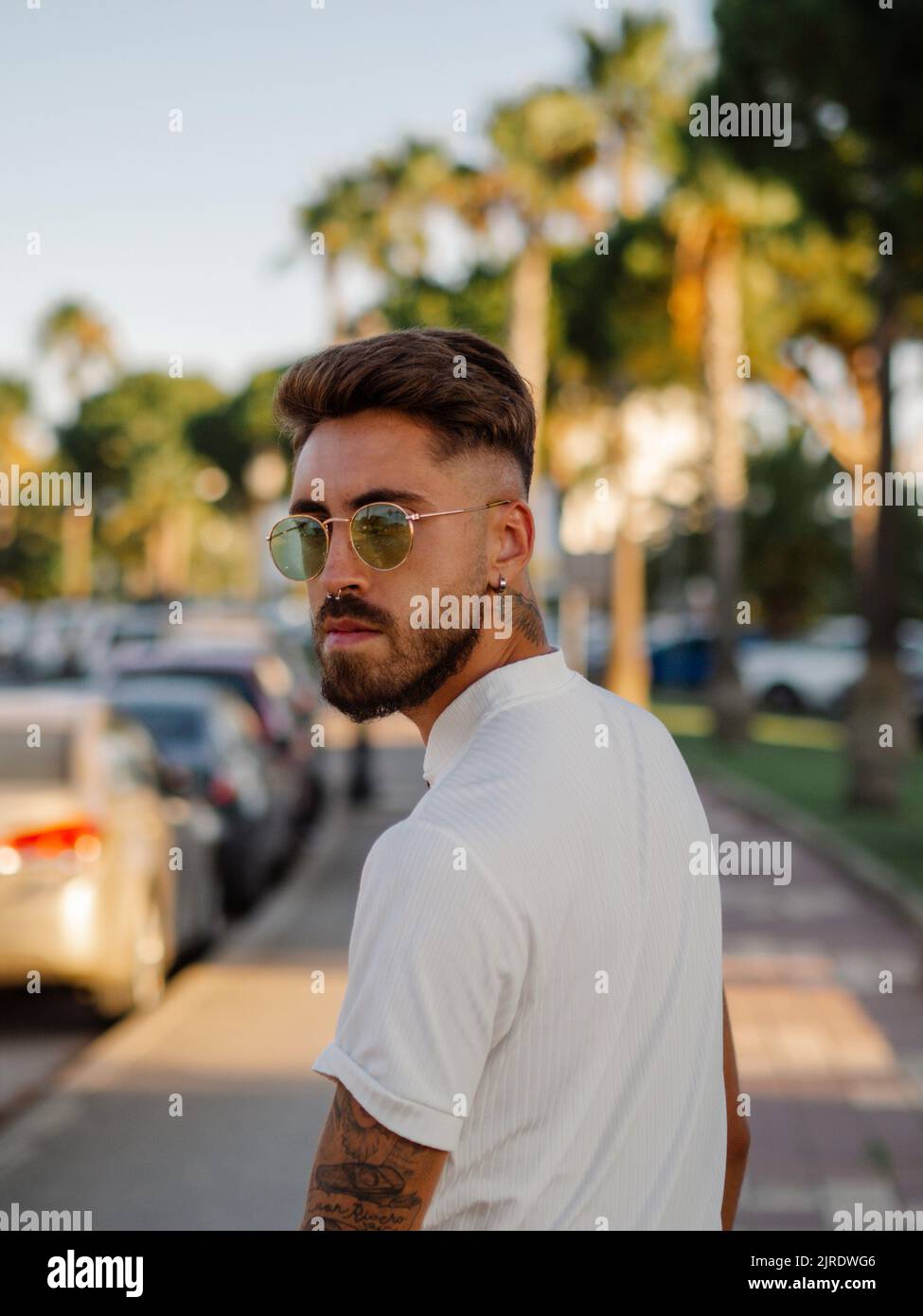 A young Spanish handsome man with a stylish hairstyle, tattoos, and ...